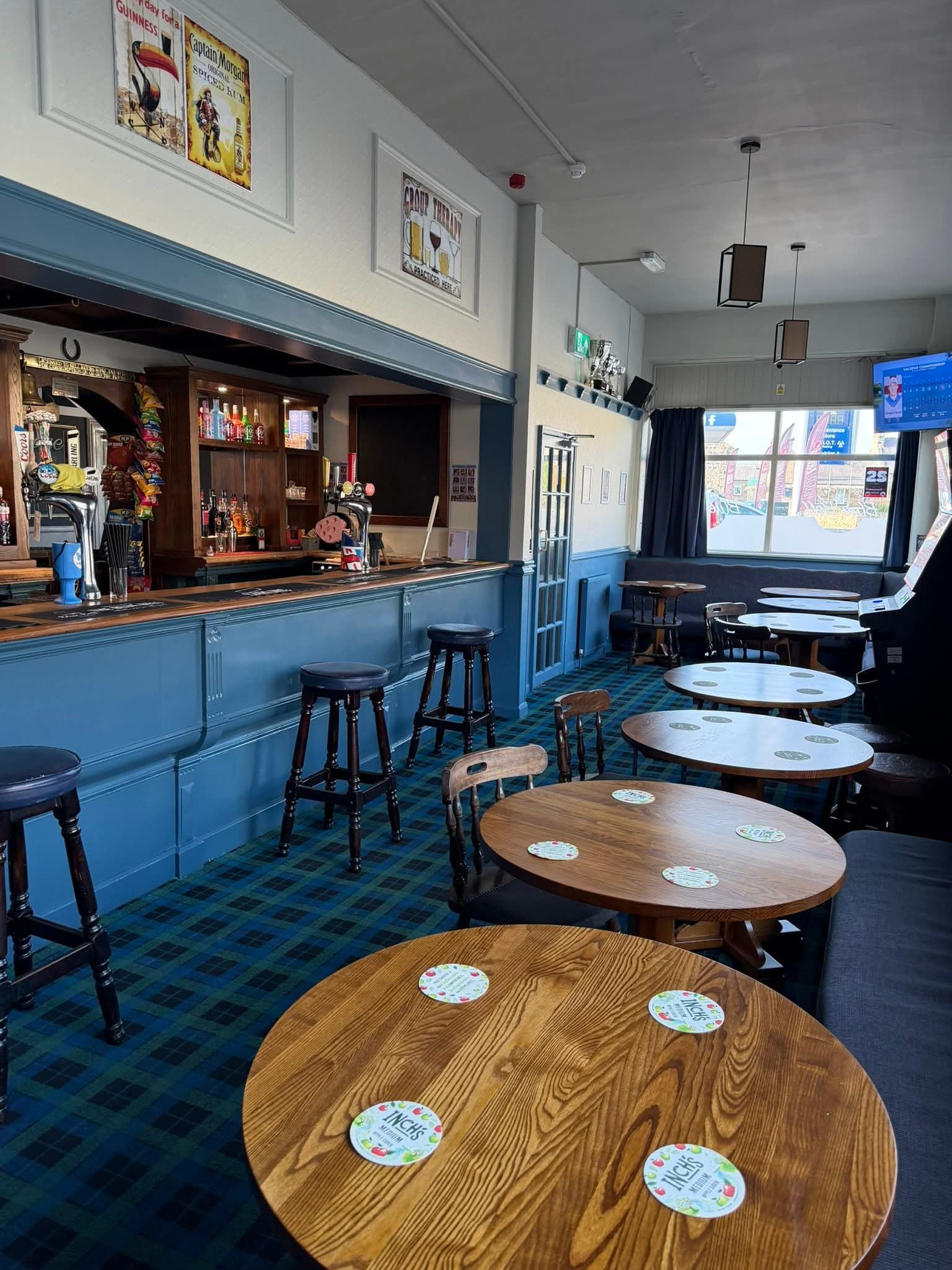 Lounge area with dark blue wainscoting, wooden tables with white ...